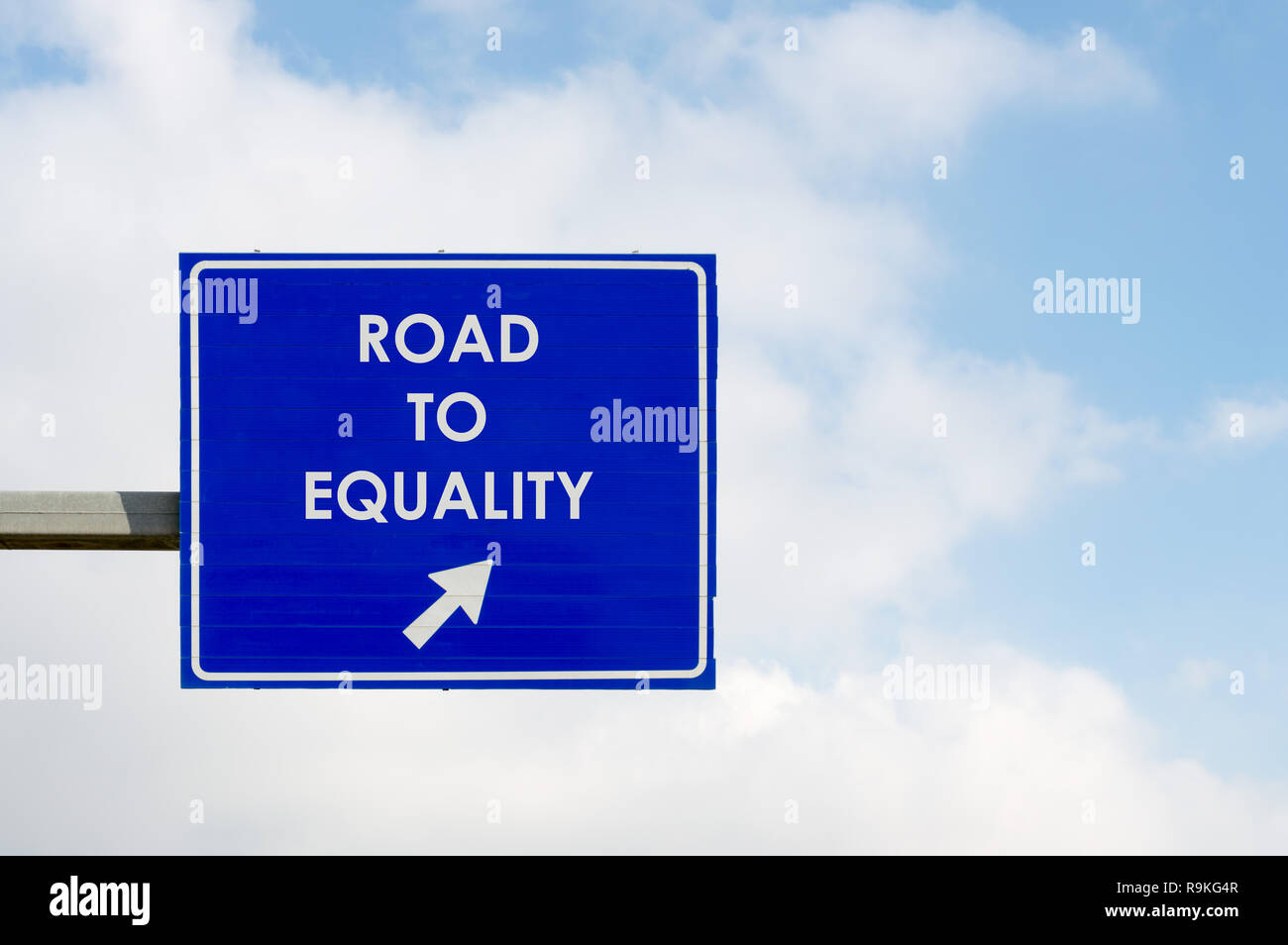 Blue road sign displaying Road to Equality words on blue sky and white ...