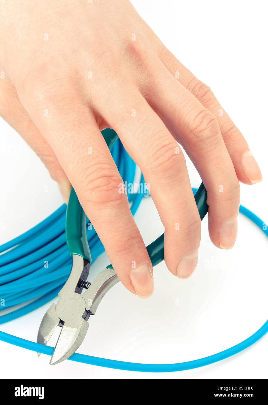 Hand with pliers or nippers is cutting blue cable for using in ...