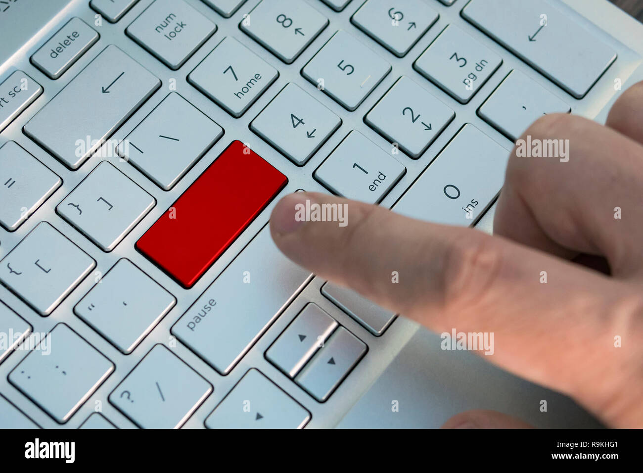 Man hand push button. Red button on grey silver laptop keyboard. copy ...