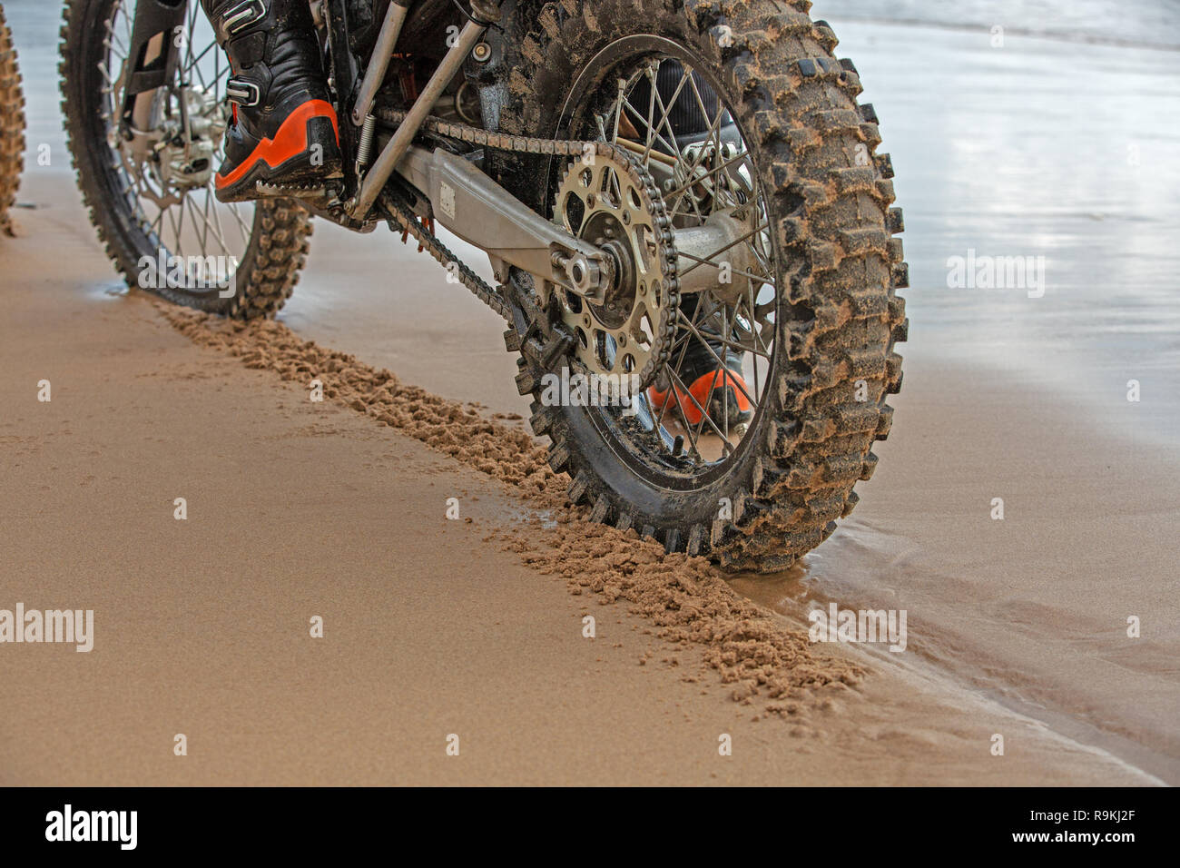 motorcycle wheels leave footprints in the wet sand on the beach Stock ...