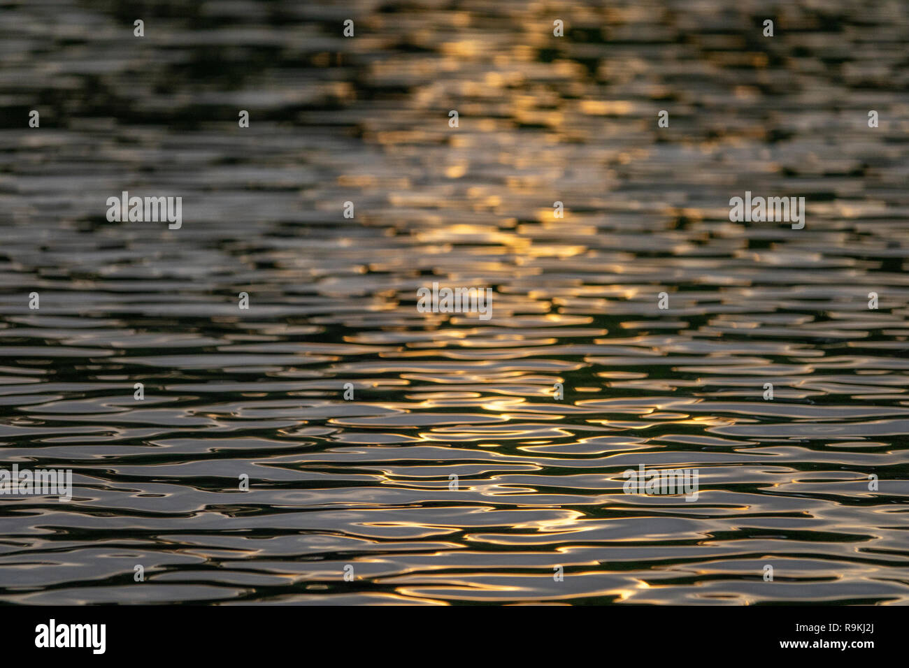 Setting sun reflecting on river water patterns Stock Photo - Alamy