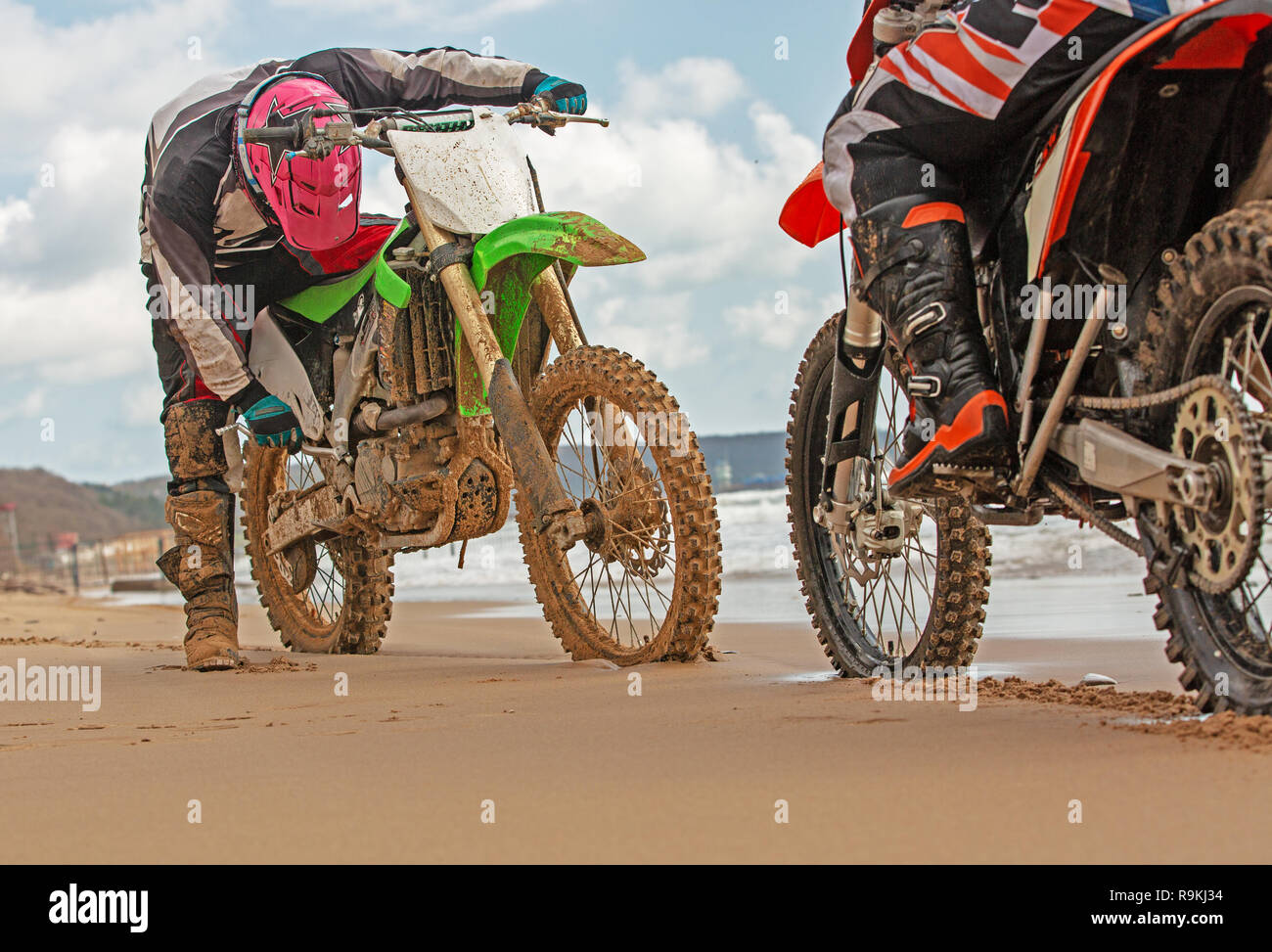 Two Motorcyclists in a protective suit sitting on motorbikes opposite ...