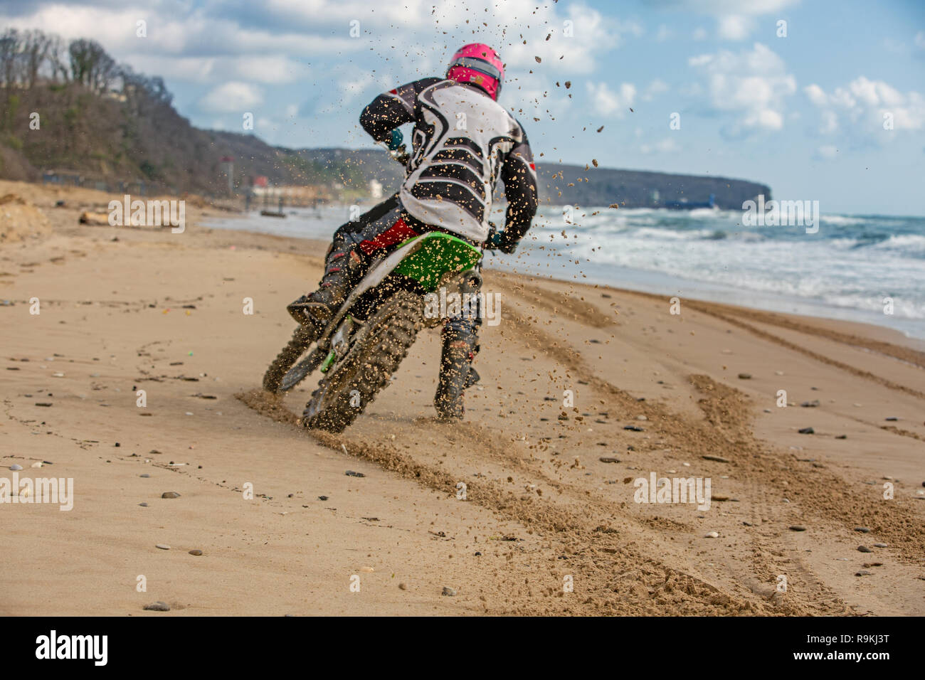 Motorcyclist in a protective suit sitting on motorbike in front of the ...