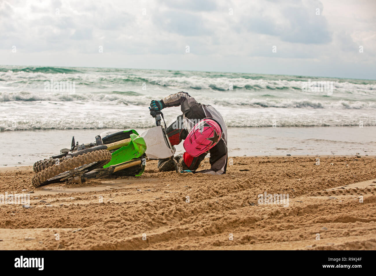 motorcyclist fell on a motorcycle on the beach against the backdrop of ...