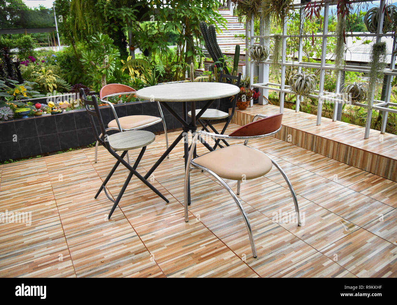 Landscaping with table set in garden with plants and trees background ...