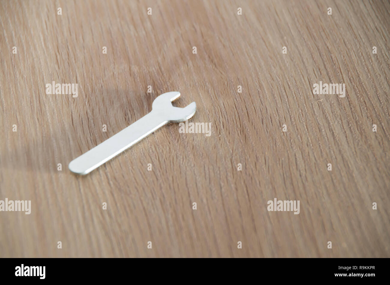 Tiny spanner on a wooden bench isolated Stock Photo - Alamy