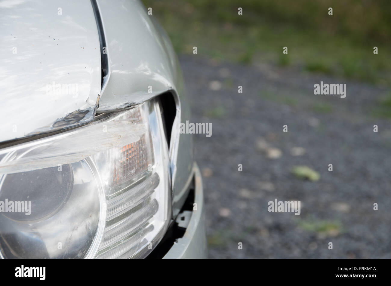 Damaged car headlight and panels after a collision in wet weather Stock ...