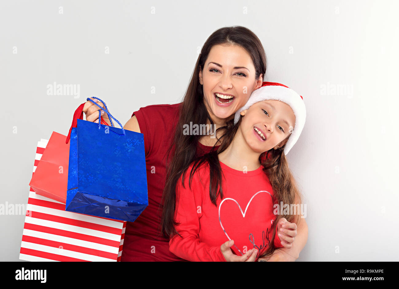 Happy laughing mother with open mouth hugging with love her cute joying ...