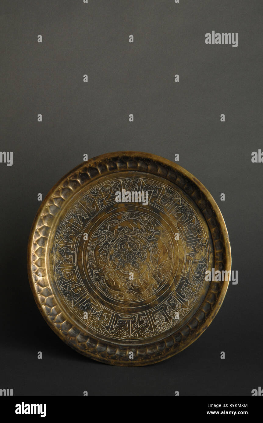 ancient oriental metal tray on dark background. antique bronze ...