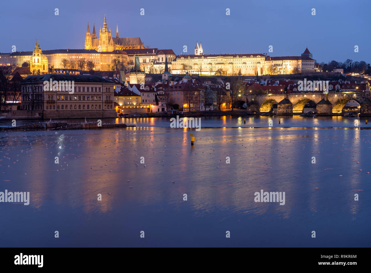Prague Castle and Charles Bridge at sunset with reflection on Vltava ...