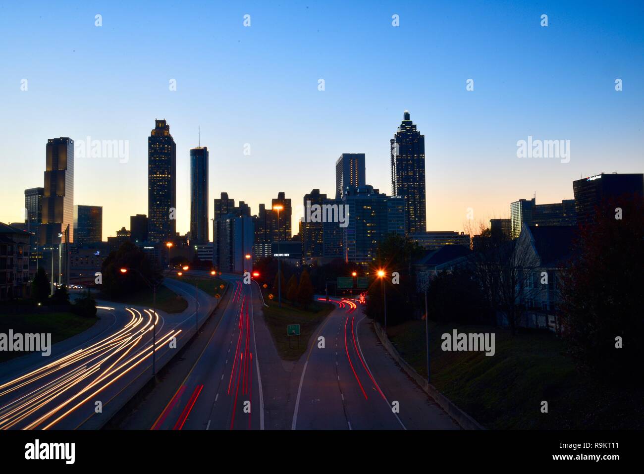 Atlanta downtown skyline lit up at sunset, along busy highway at rush ...