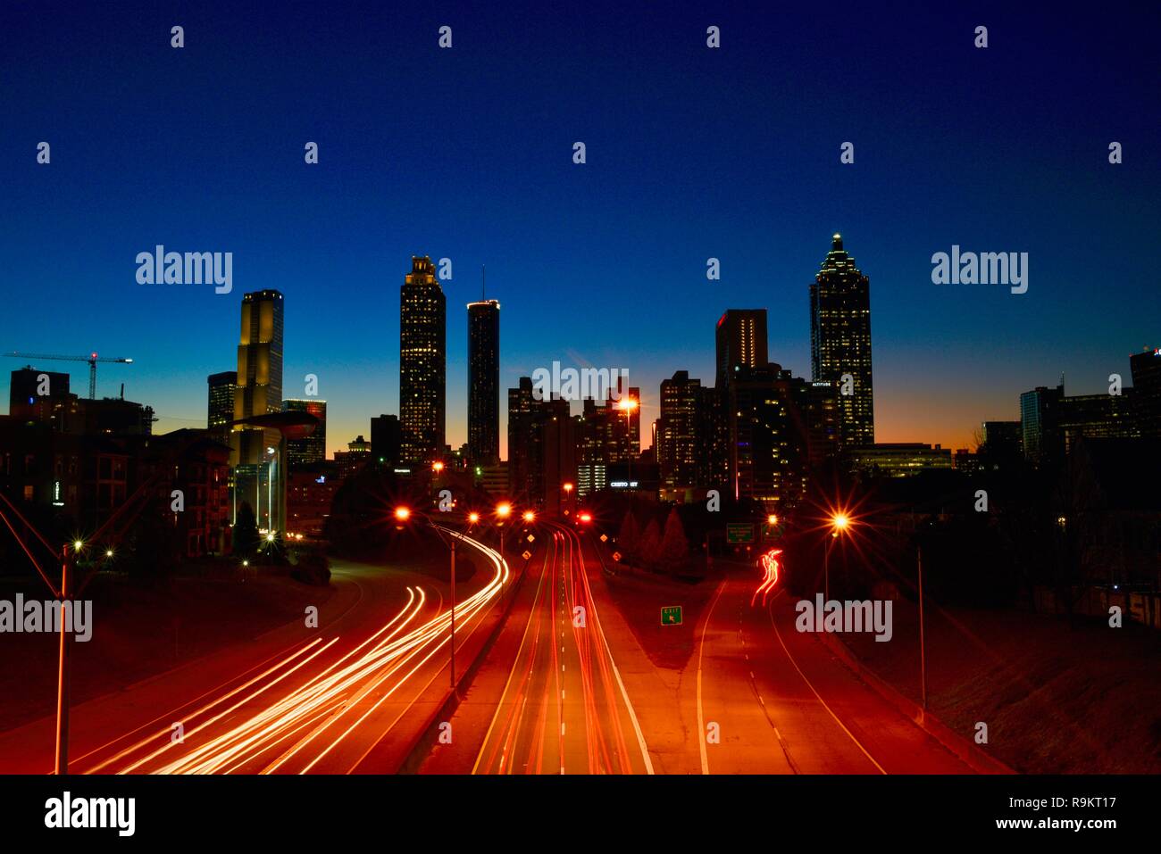 Atlanta downtown skyline lit up at sunset, along busy highway at rush ...