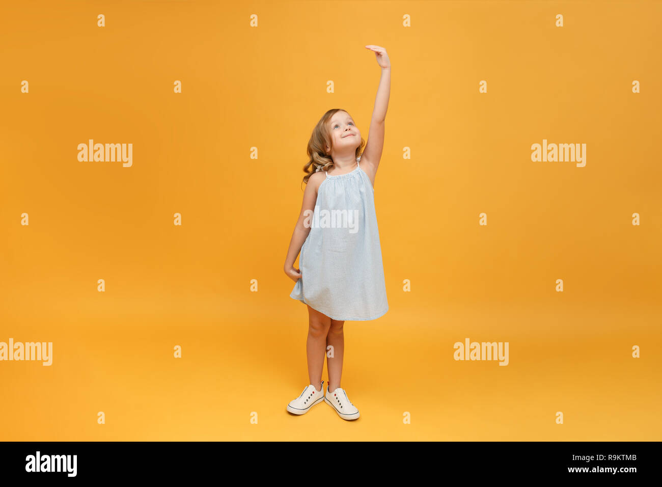 A little child measures her height on a yellow background. Concept of ...