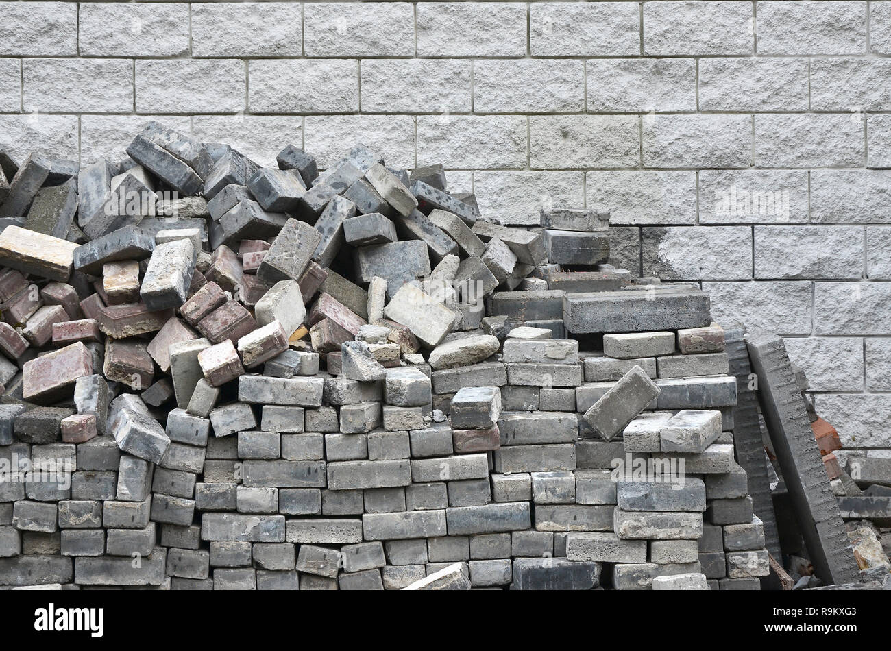 A large pile of disassembled paving tiles against the wall of light ...