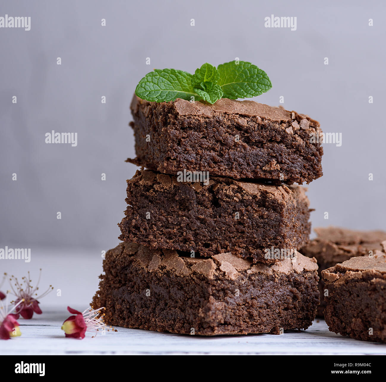 pile of square slices of baked brownie pie on a white wooden board ...