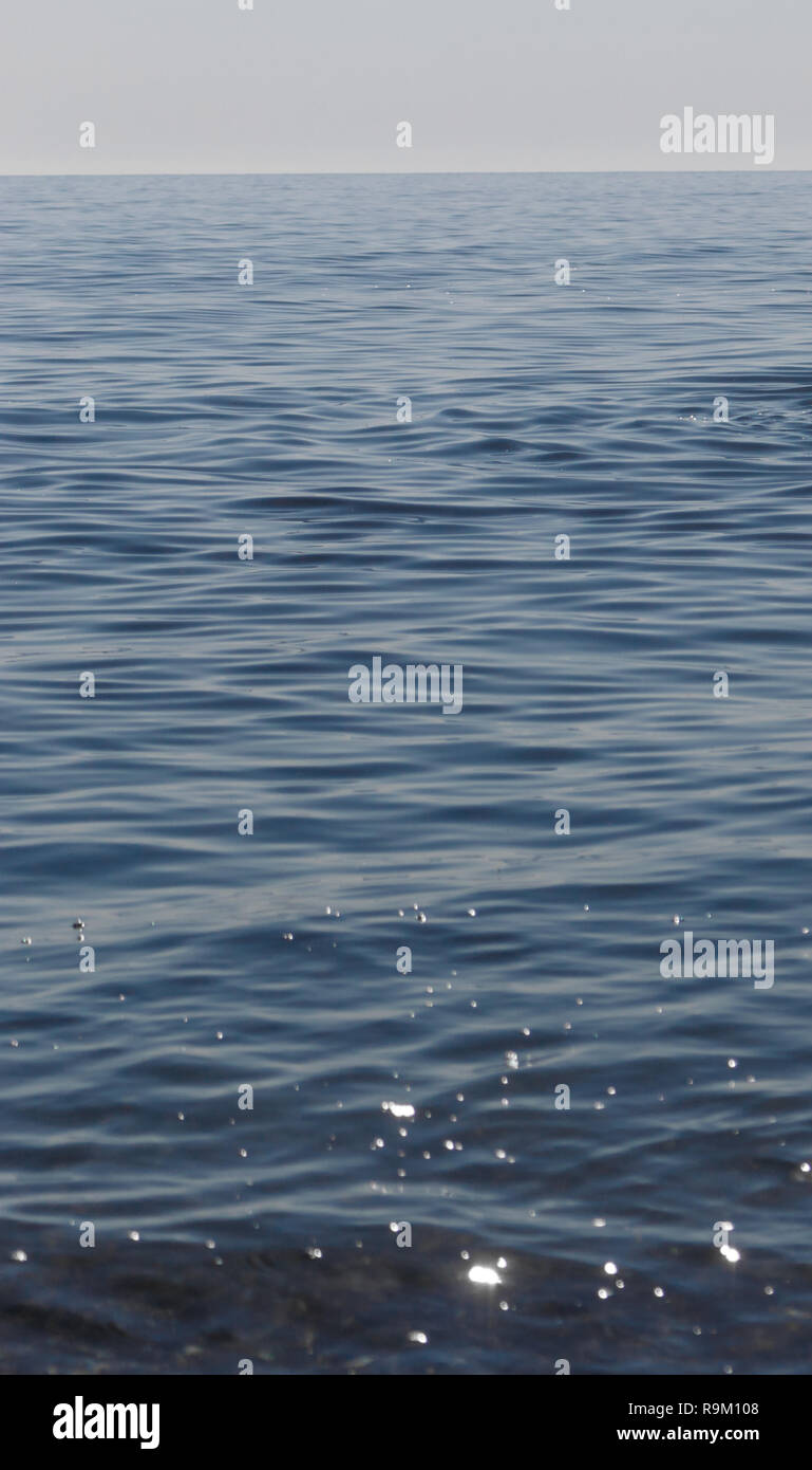 Close up of sparkling surface of sea with small waves and sky ...