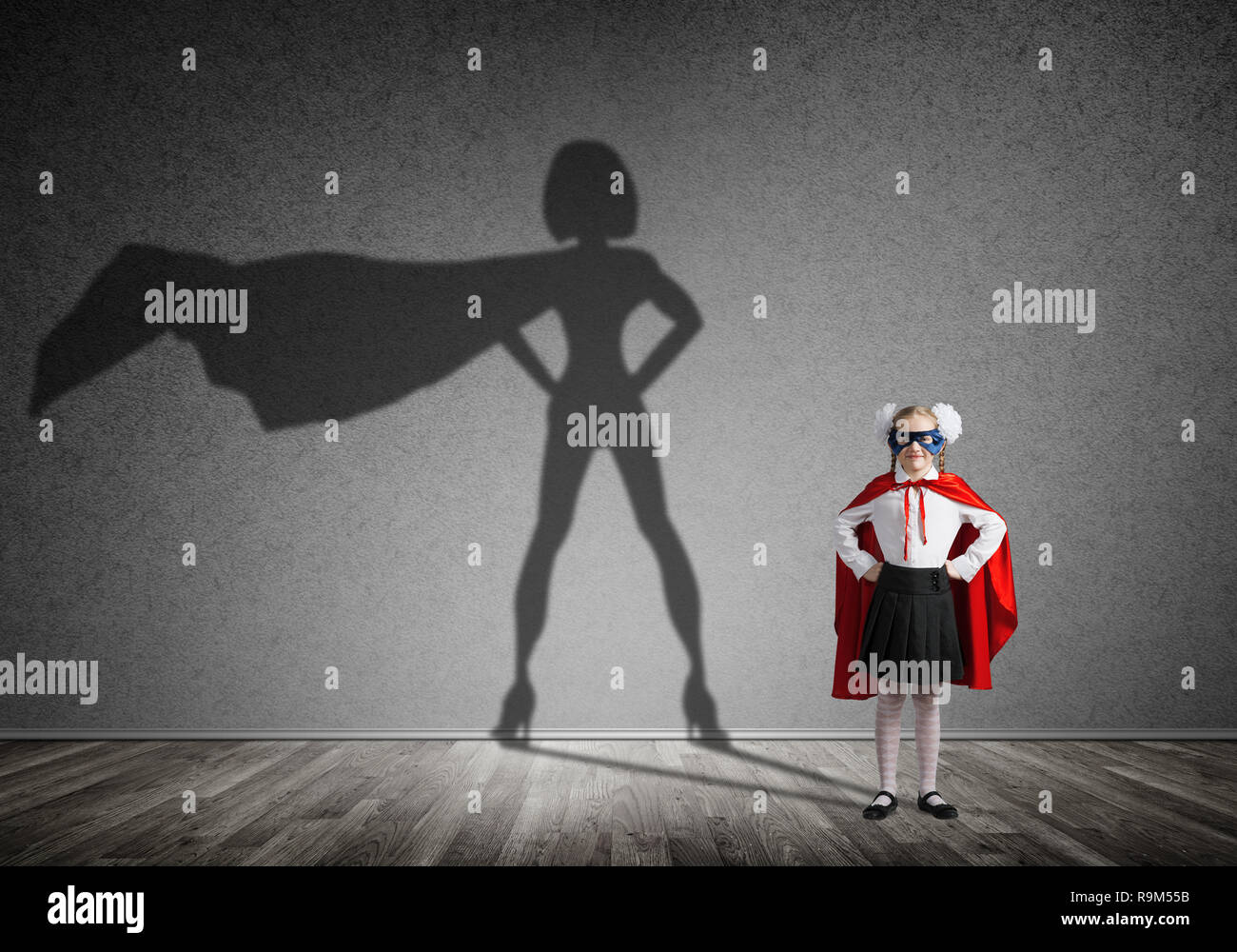 Girl power concept with cute kid guardian and shadow at wall. Mixed ...