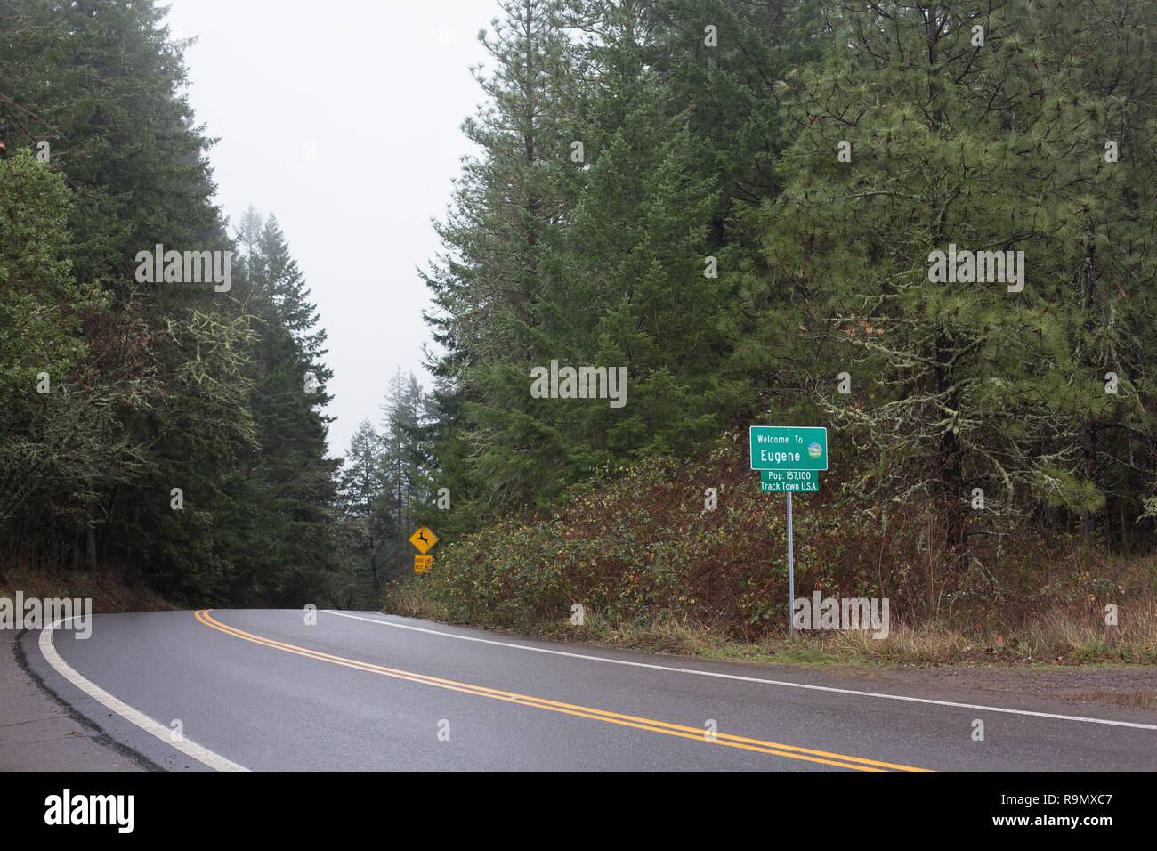 A city limits sign next to a rural highway in Eugene, Oregon, USA Stock ...