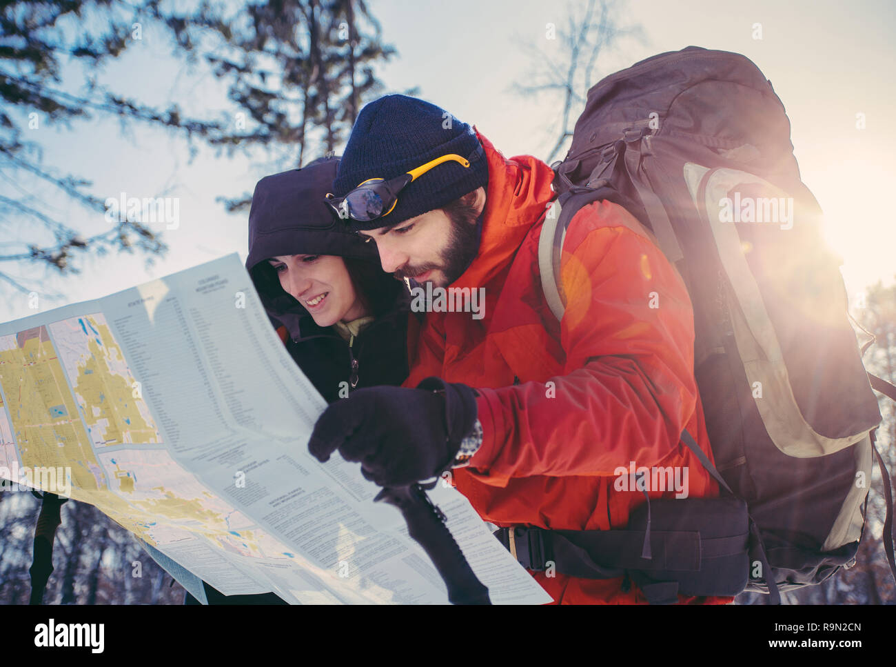 Young couple of hikers looking at map for direction Stock Photo - Alamy