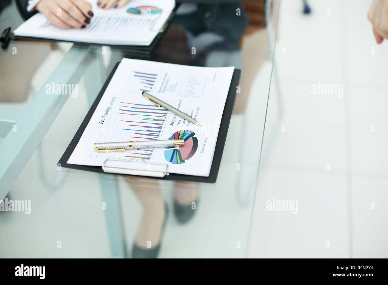 pens and financial report on the glass table in the office Stock Photo ...