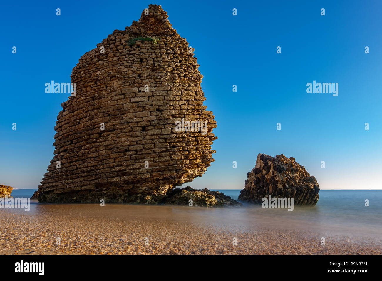 Old ruined defense tower near ocean, long exposure Stock Photo - Alamy