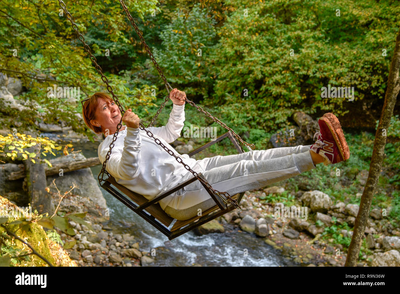 Tourist emotional woman swinging on a swing in the woods Stock Photo ...