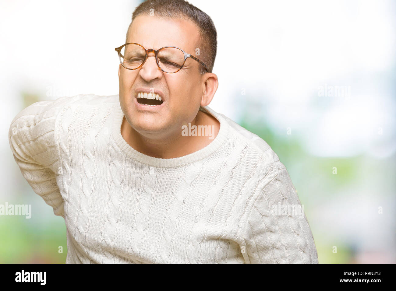 Middle age arab man wearing glasses over isolated background Suffering ...