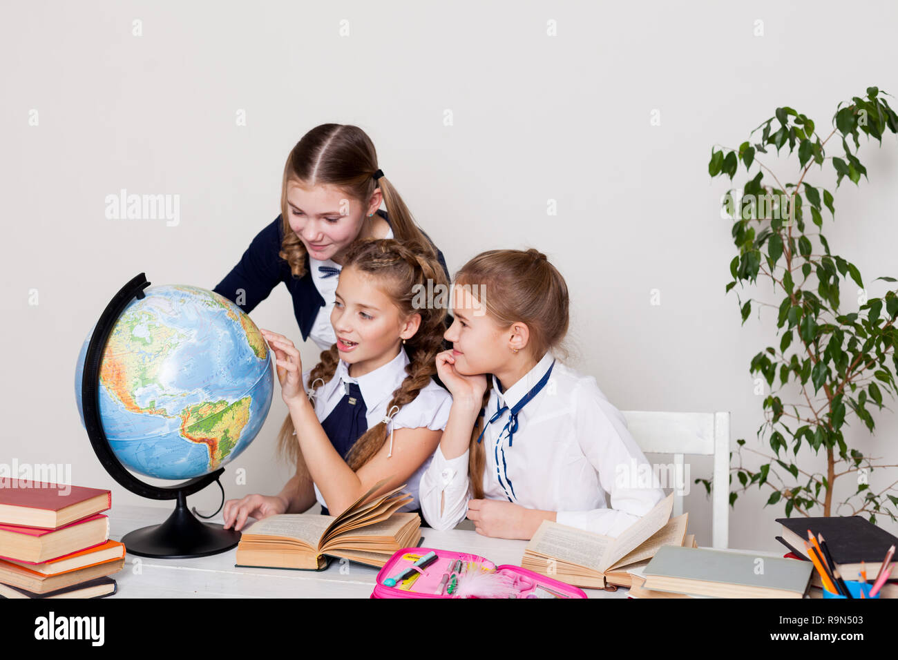 three schoolgirls girls learn world geography lesson on the map Stock ...