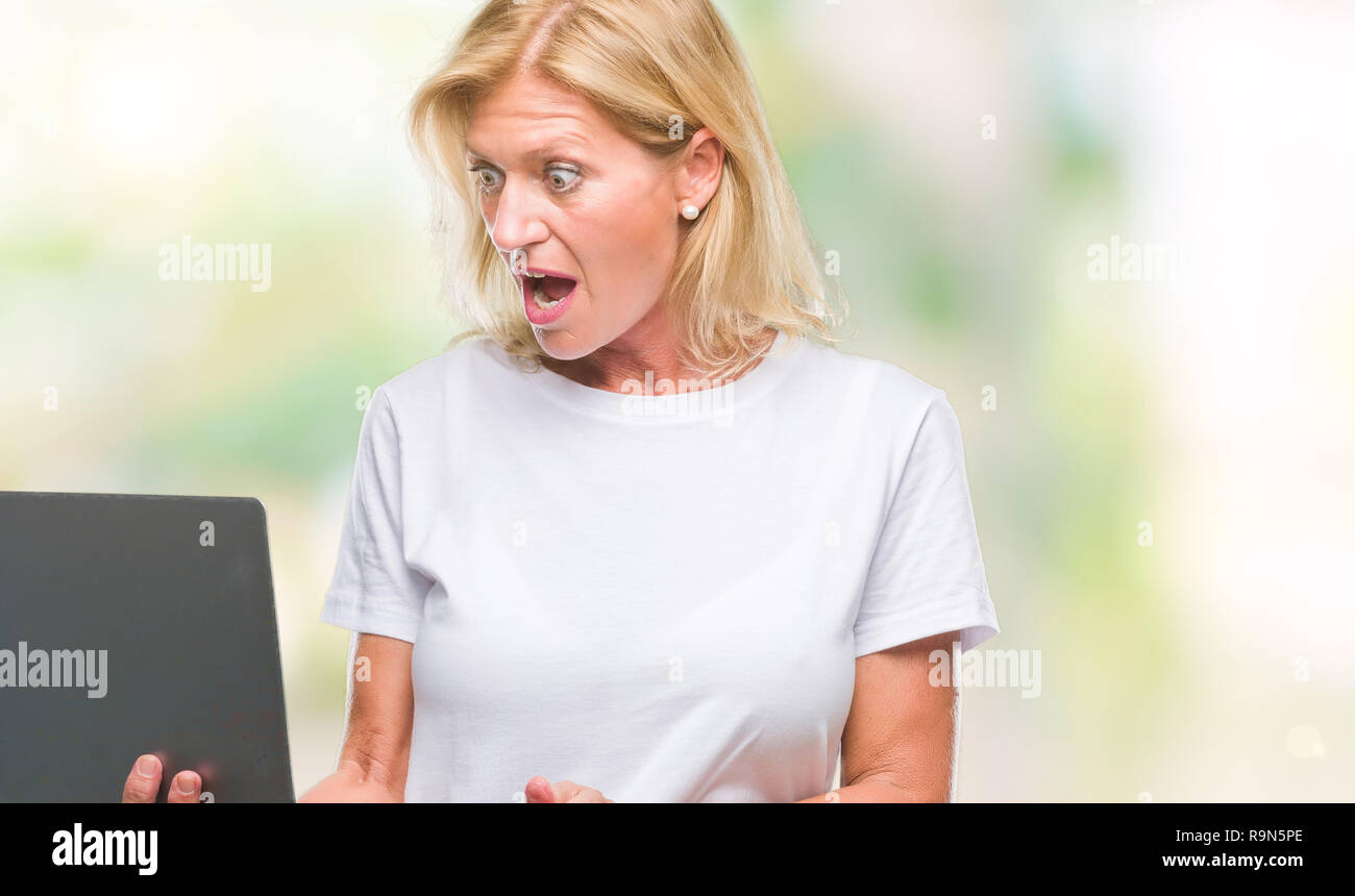 Middle age blonde woman using computer laptop over isolated background ...