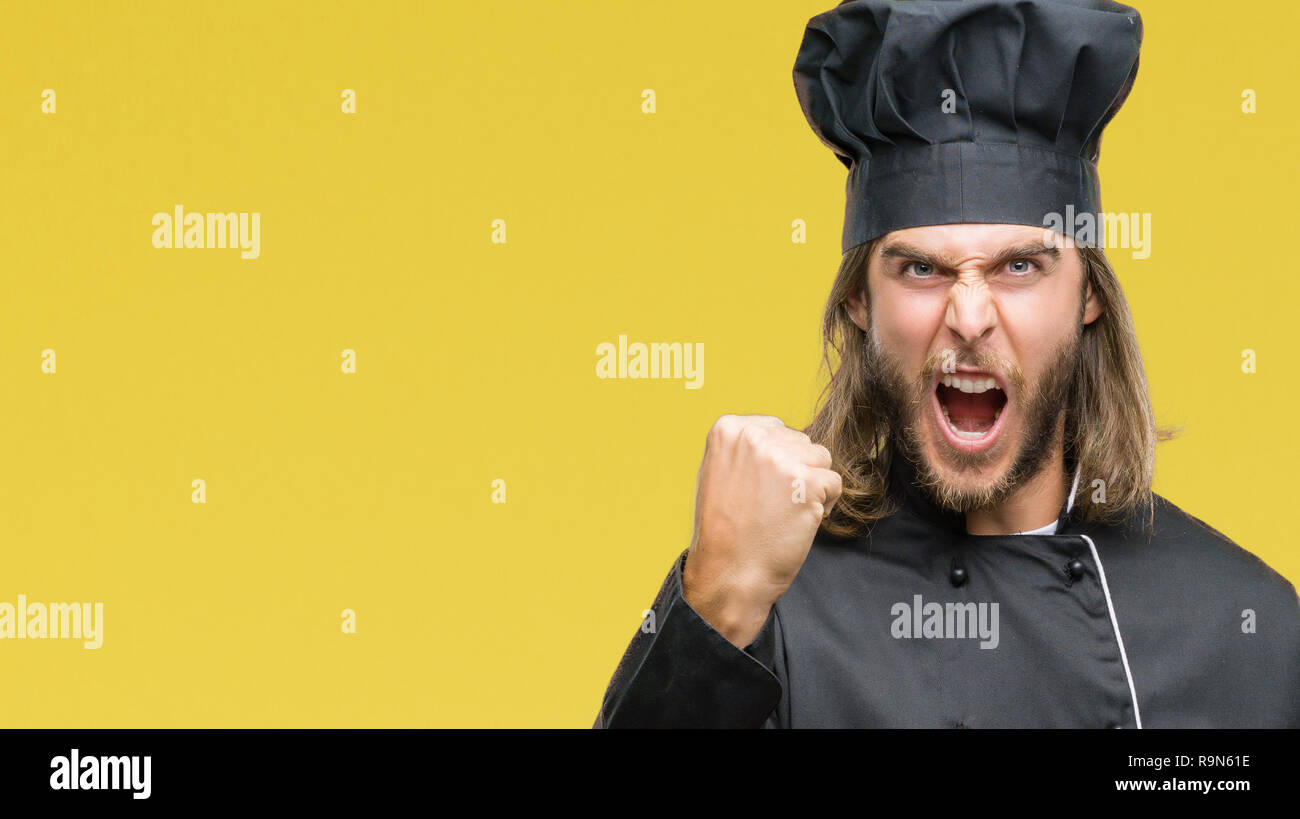 Young handsome cook man with long hair over isolated background angry ...