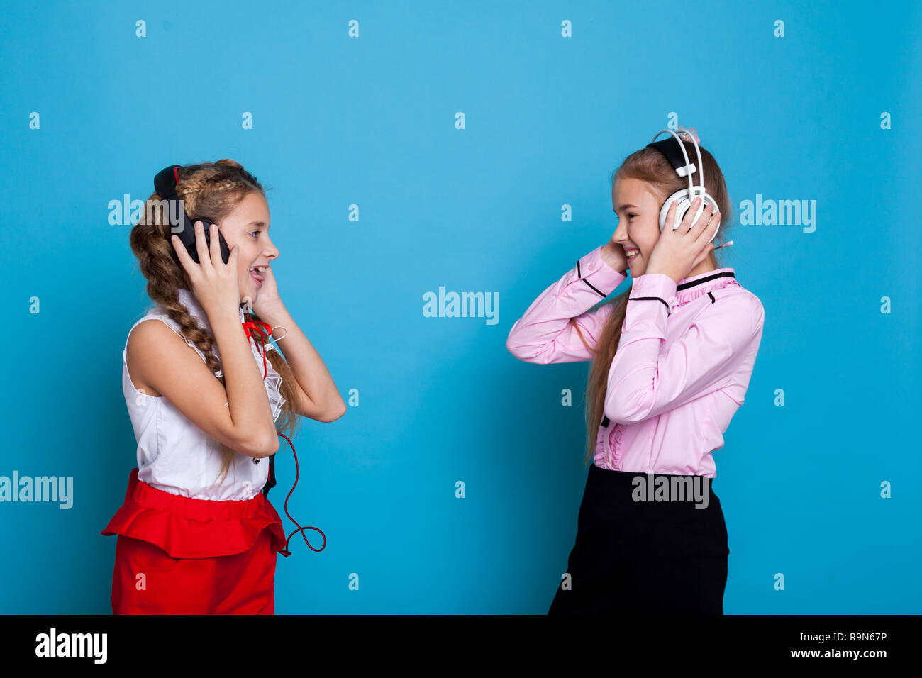 two girls are listening to music with headphones and dance Stock Photo ...