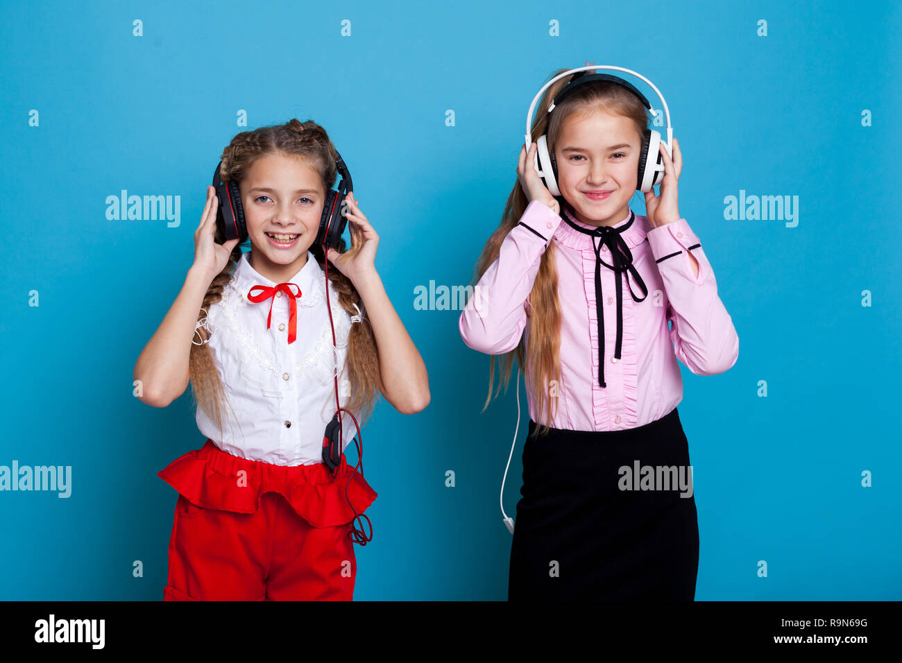 two girls are listening to music with headphones and dance Stock Photo ...