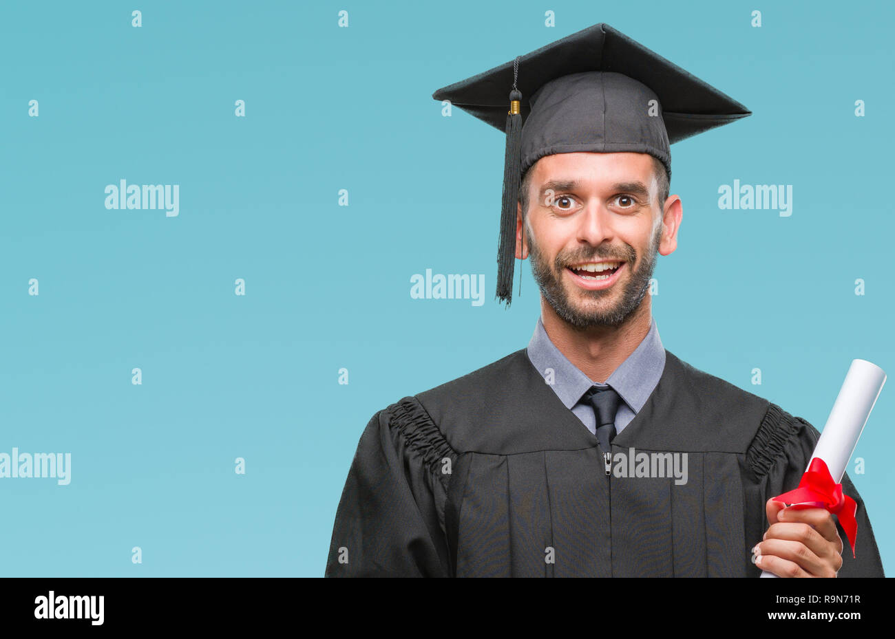 Young handsome graduated man holding degree over isolated background ...