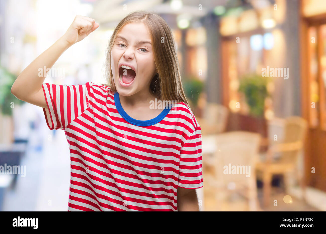 Young beautiful girl over isolated background angry and mad raising ...