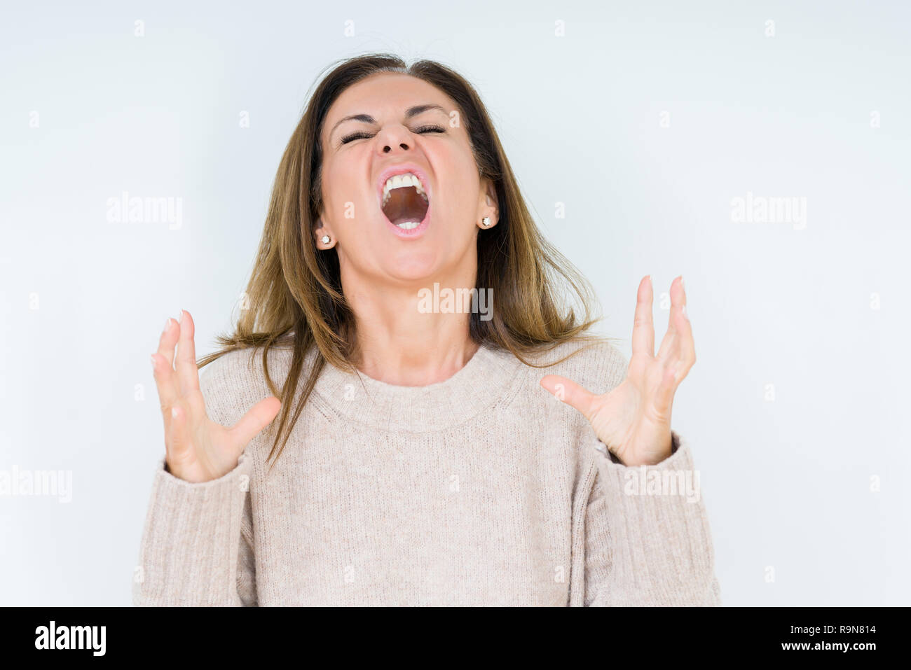 Beautiful middle age woman over isolated background crazy and mad ...