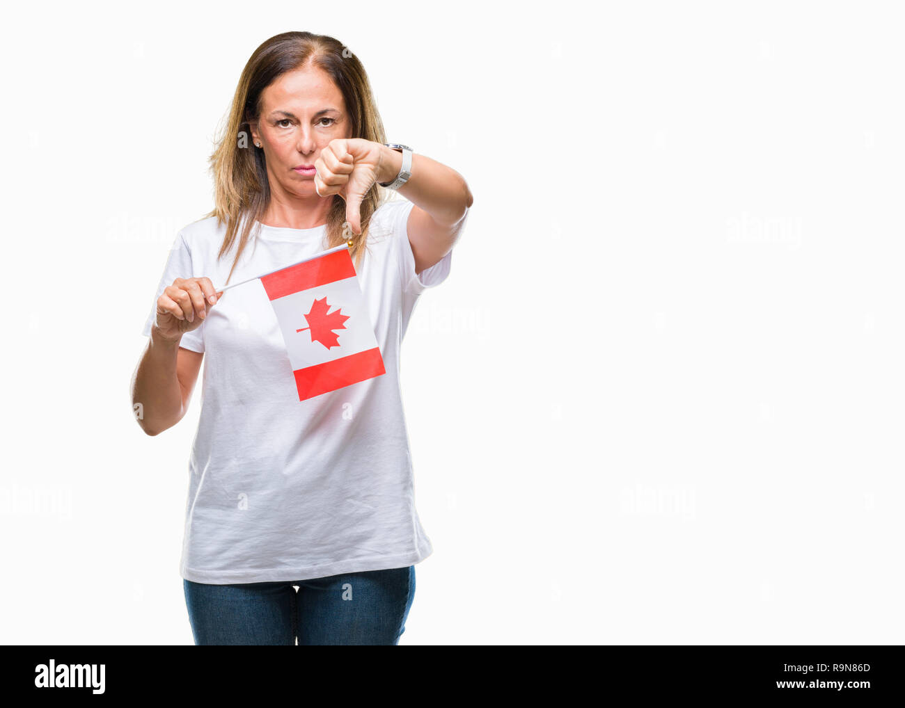 Middle age hispanic woman holding flag of Canada over isolated ...