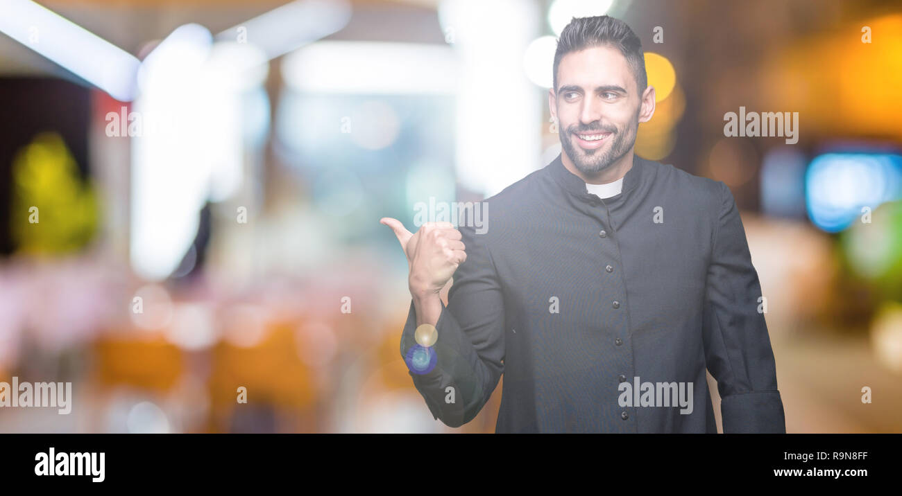 Young Christian priest over isolated background smiling with happy face ...