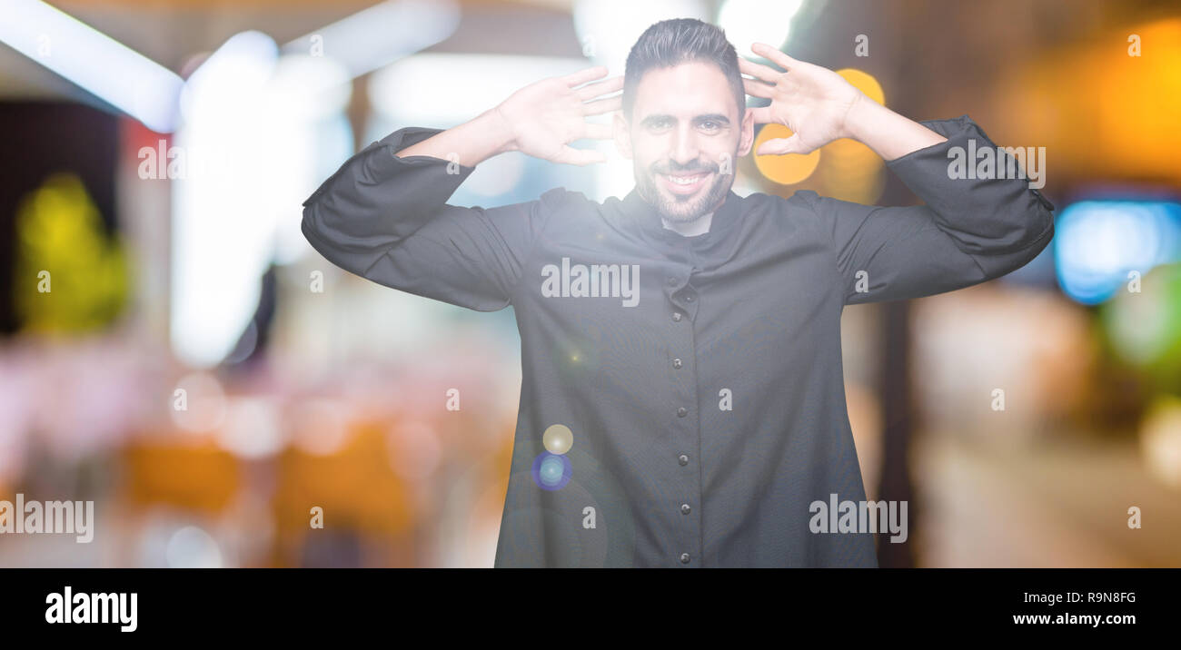 Young Christian priest over isolated background Relaxing and stretching ...