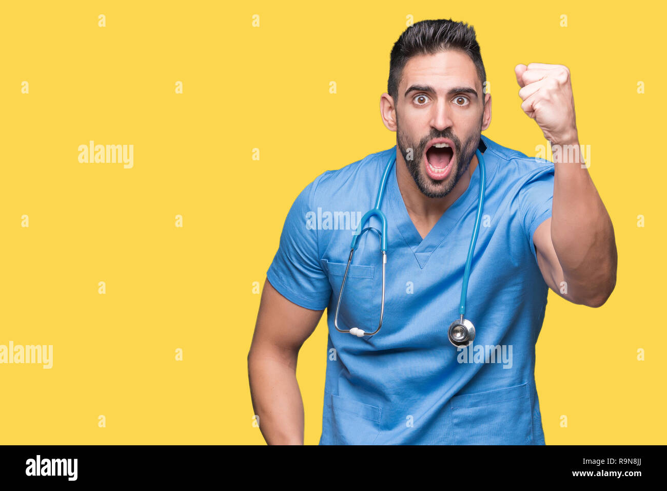 Handsome young doctor surgeon man over isolated background angry and ...