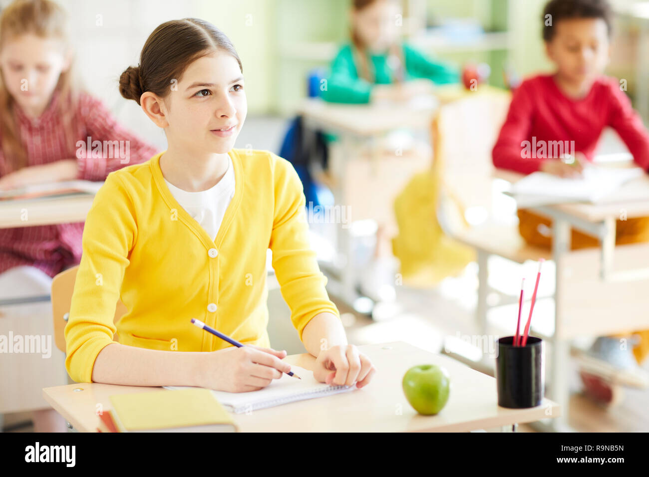 Inquisitive schoolgirl making notes at lesson Stock Photo - Alamy