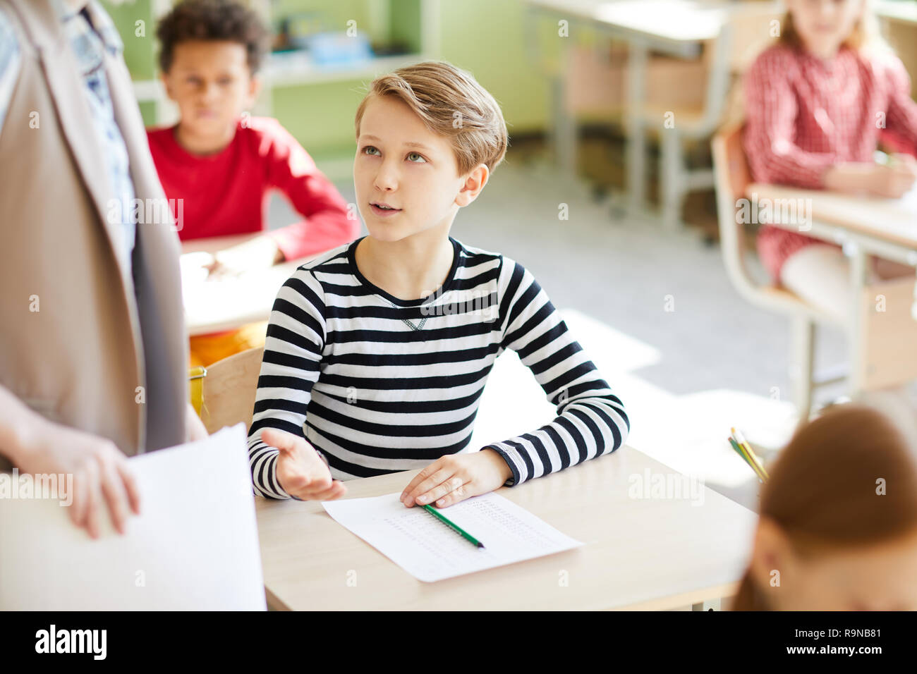 Boy asking teacher about test Stock Photo - Alamy