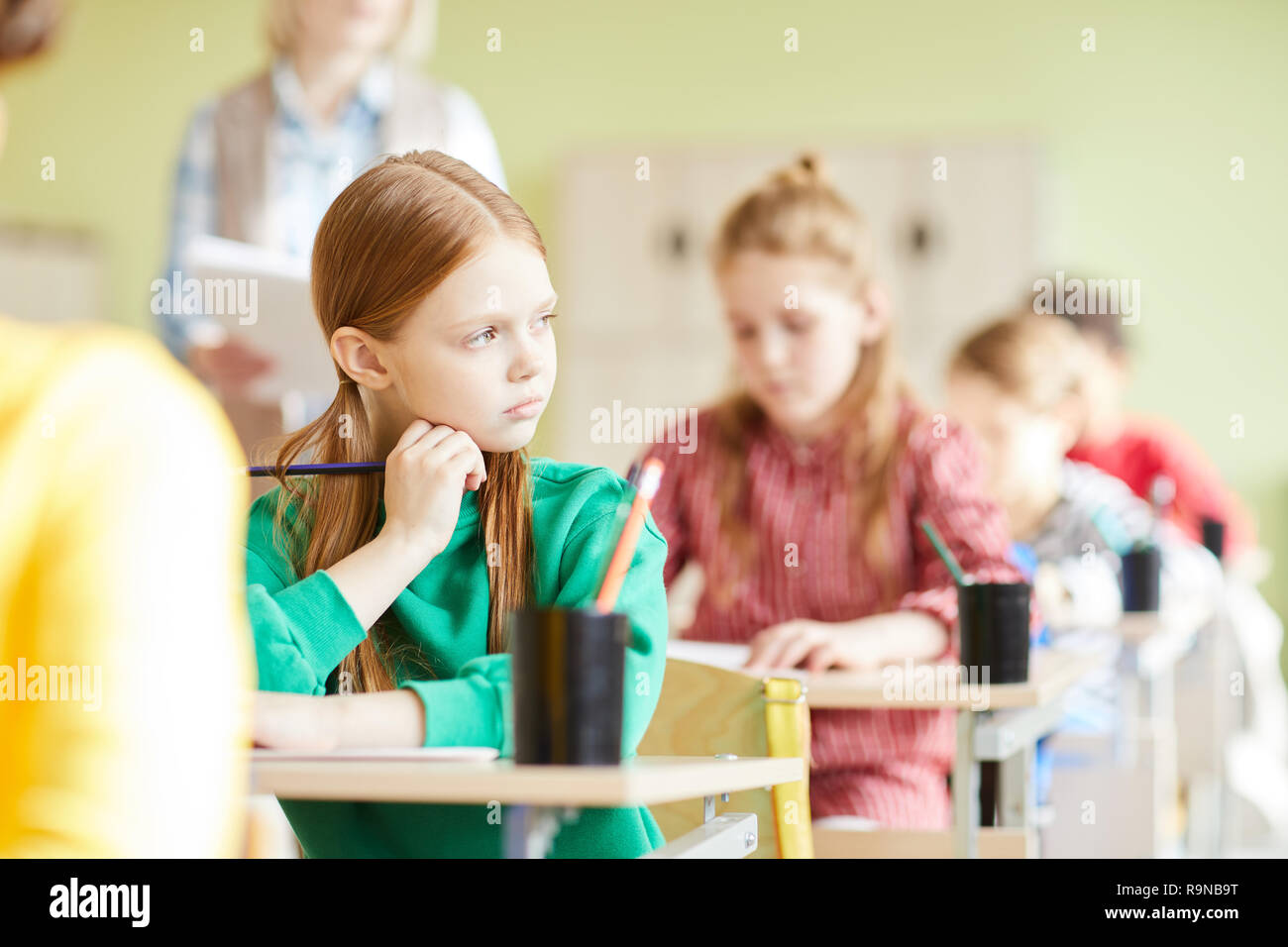 Sad girl sitting in classroom hi-res stock photography and images - Alamy