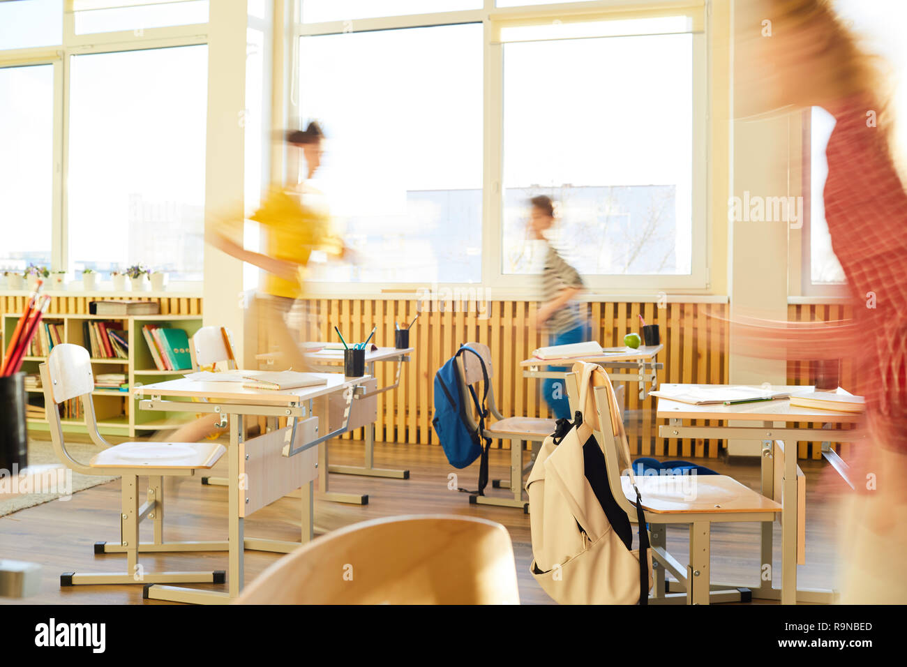 School children running in classroom Stock Photo - Alamy