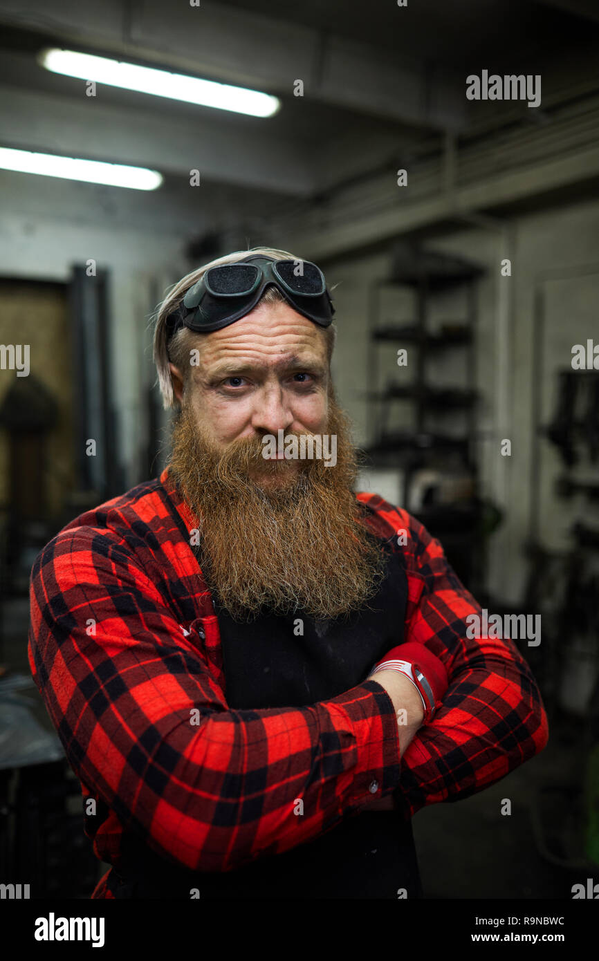 Scowling brutal blacksmith in workshop Stock Photo - Alamy