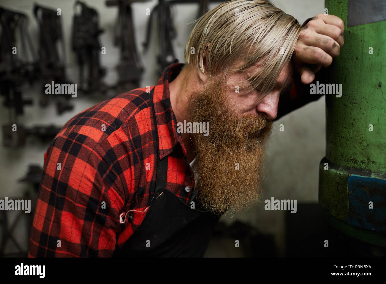 Exhausted blacksmith without strength Stock Photo - Alamy