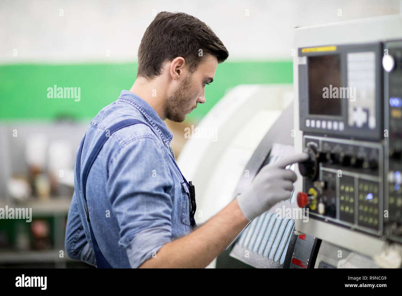 Factory worker operating industrial machine hi-res stock photography ...