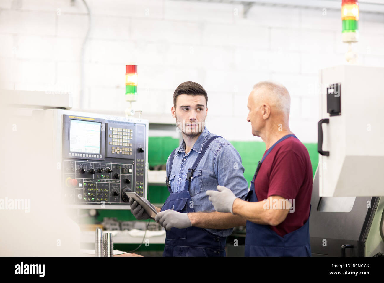 Two workers in factory on the machine Stock Photo - Alamy
