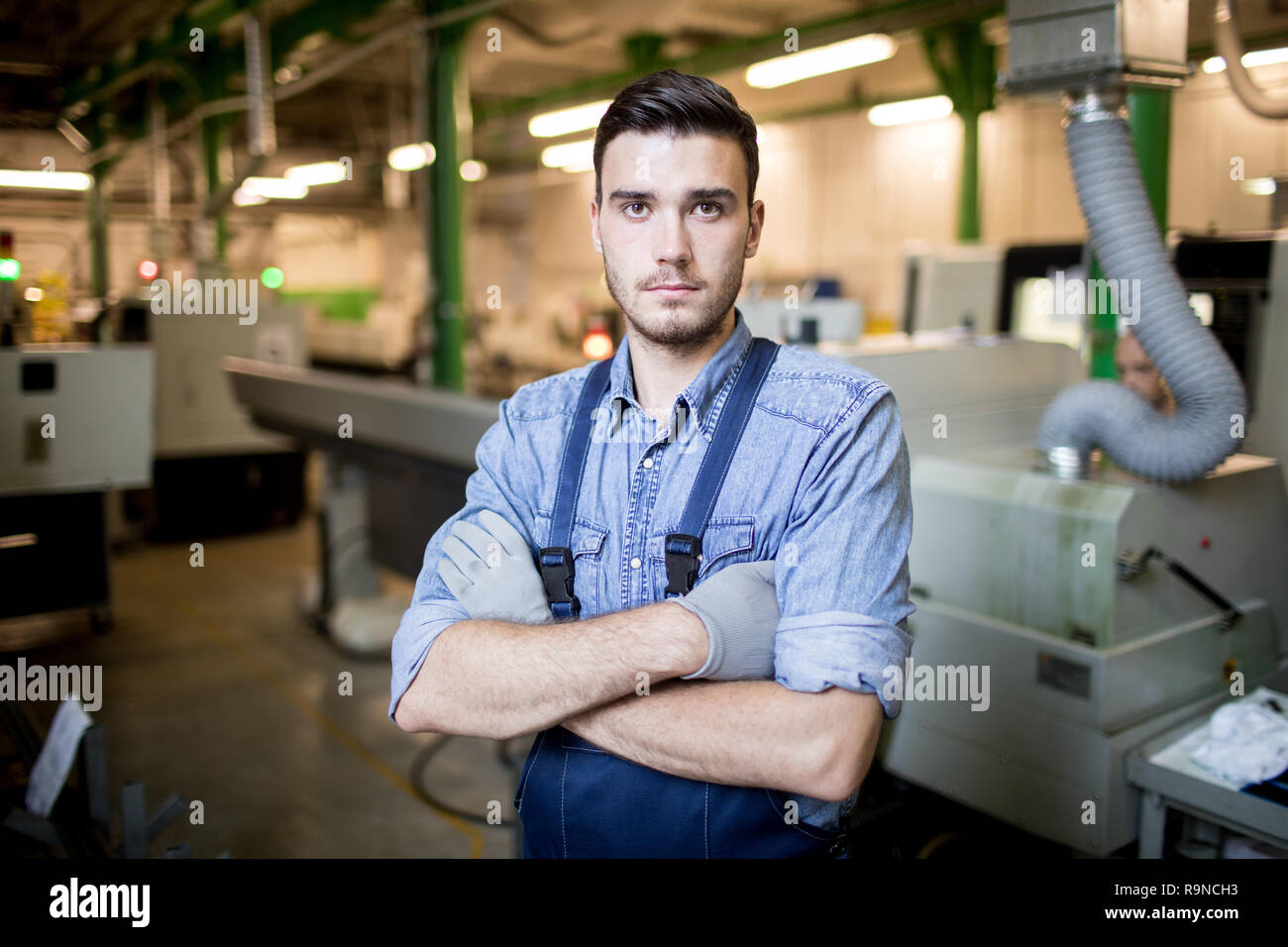 Worker standing in factory Stock Photo - Alamy