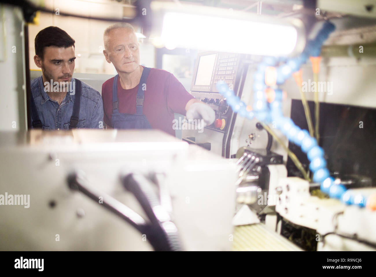 Factory workers working in team Stock Photo - Alamy
