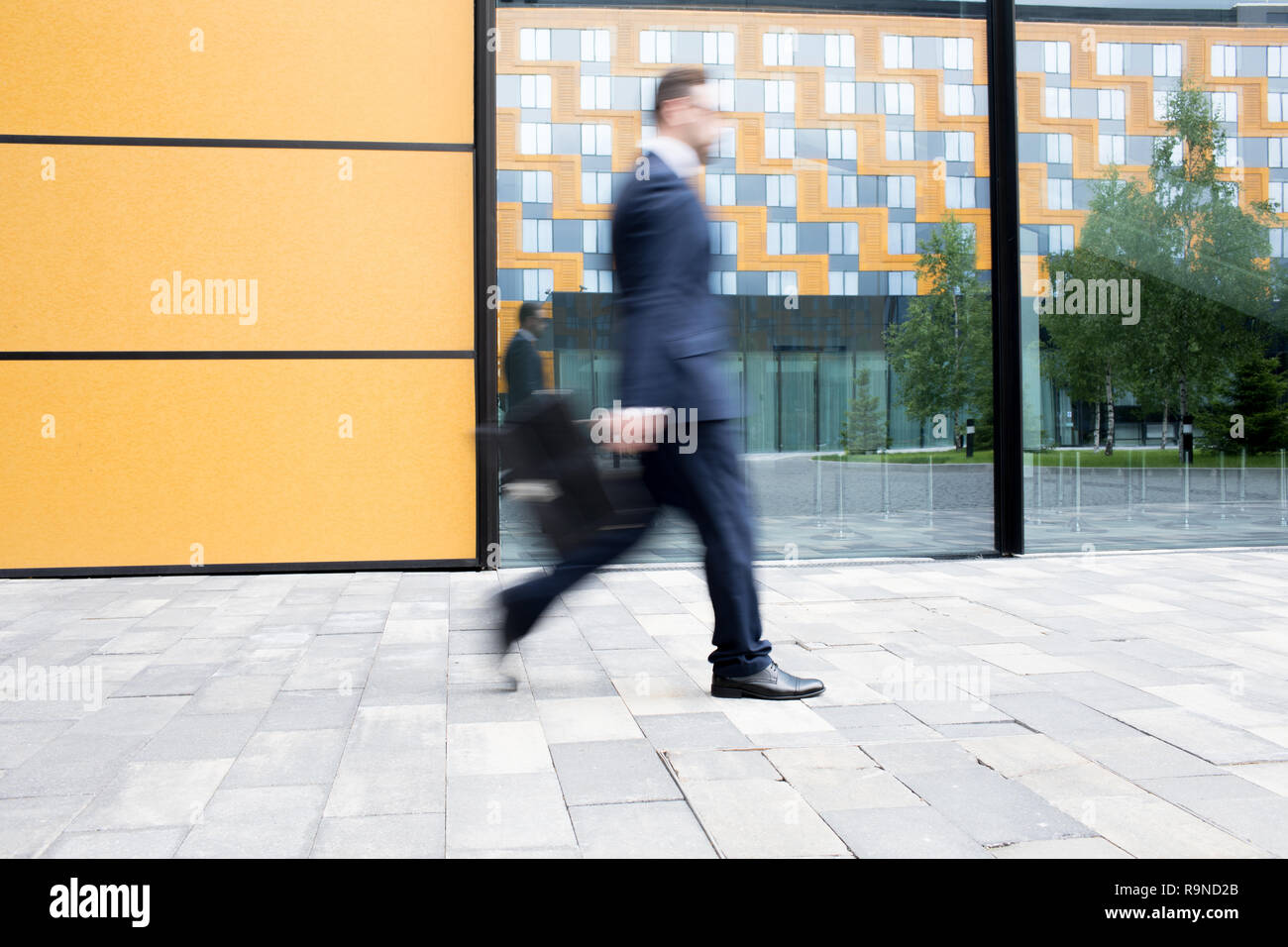 Anonymous businessman walking on sidewalk Stock Photo - Alamy